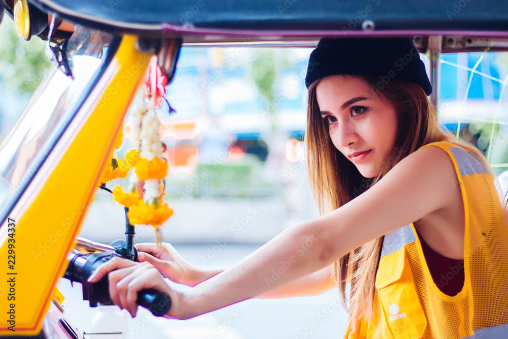 Beautiful girl driving a tuk tuk. Stock Photo | Adobe Stock