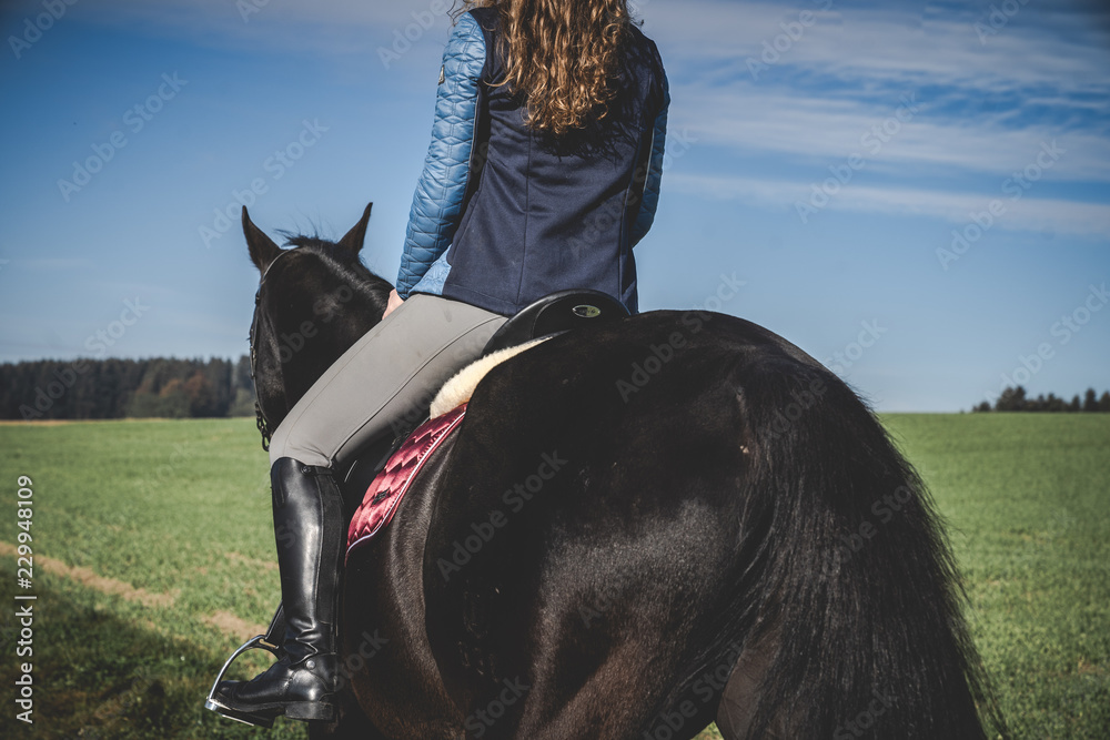 Junge schöne Frau und schwarzes Pferd Ausritt, reiten, Derssur ...