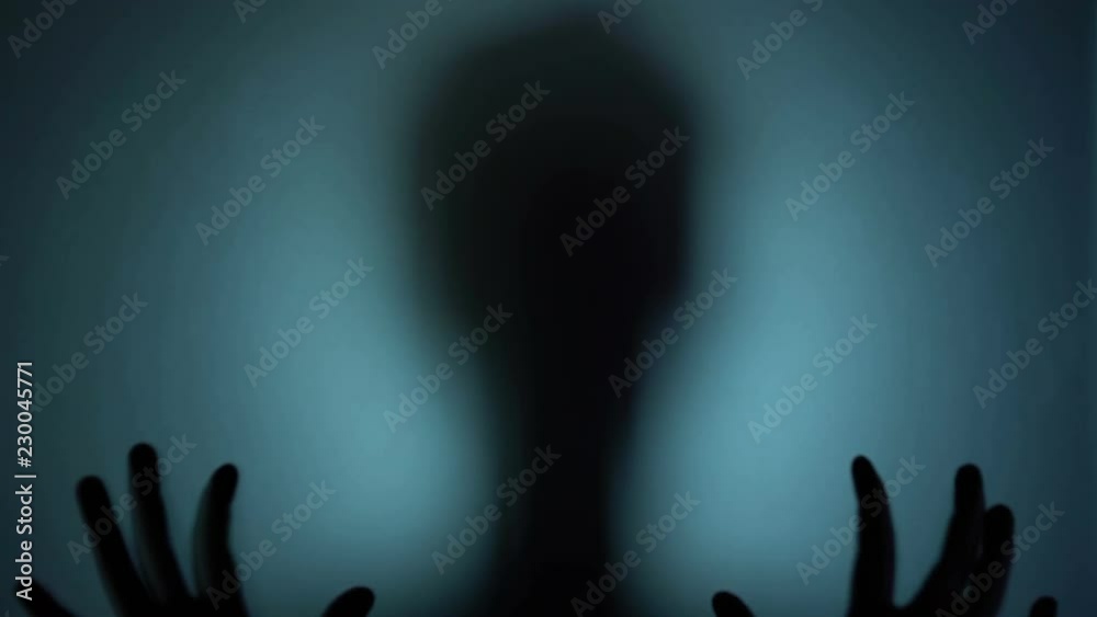 Deranged person convulsing behind the glass, psycho, spooky horror ...