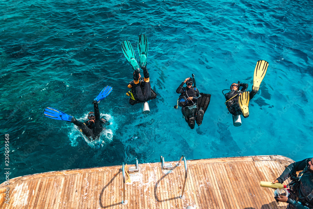 scuba diver sit on the yacht and ready to dive. Stock Photo | Adobe Stock