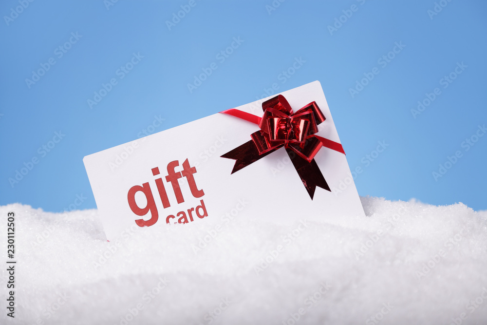 Gift card with red ribbon on snow Stock Photo | Adobe Stock