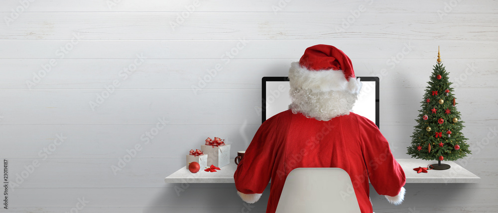 Santa Claus working on a computer in his office during Christmas ...