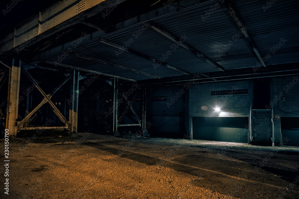 Dark and empty urban city lot under a vintage railway bridge at night ...