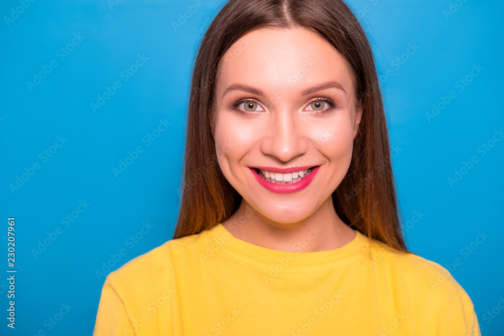 Cute brunette woman with long hair posing in yellow t-shirt on a blue ...