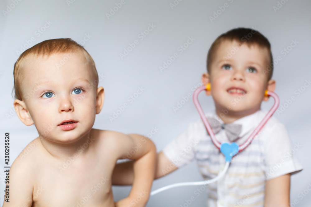 Two little boys using stethoscope. Children playing doctor and patient ...