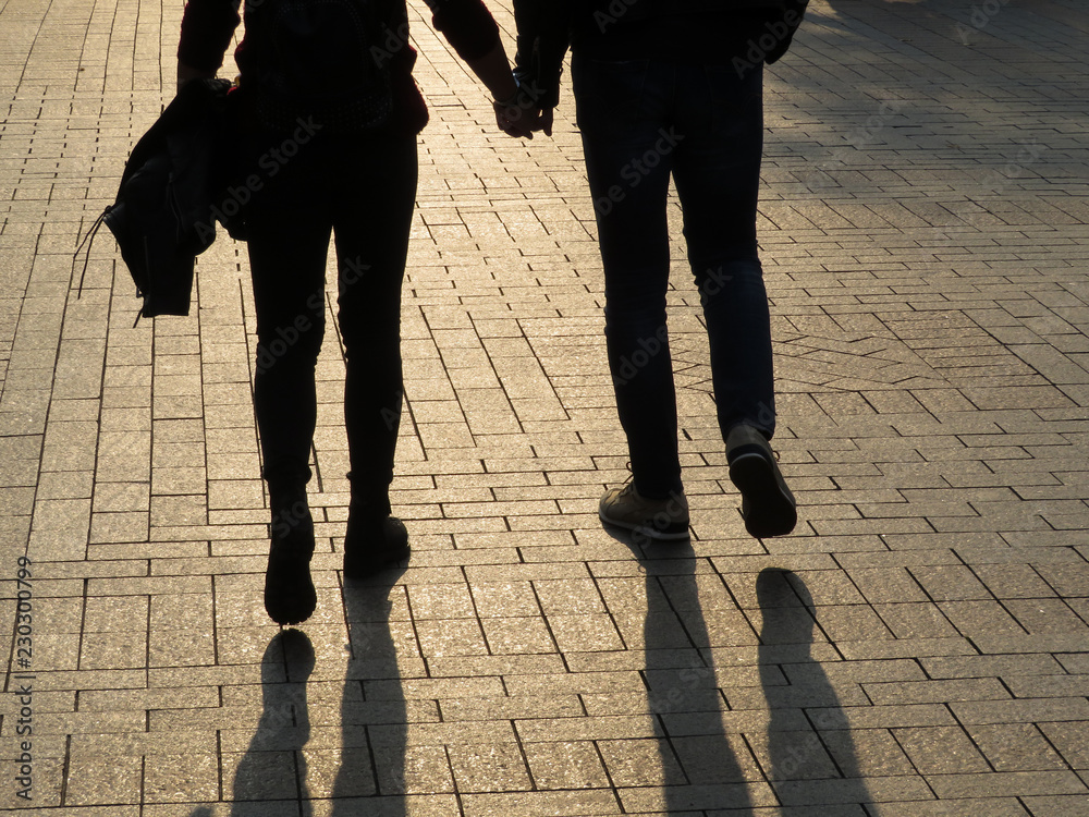 Two People Walking In The Street