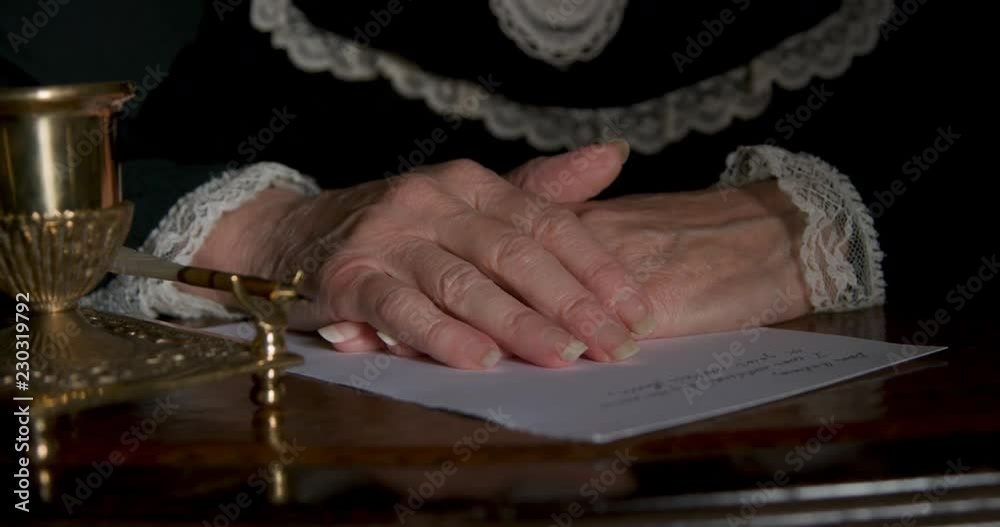 An ornate inkwell with a holder for its fancy dip pen and the folded ...
