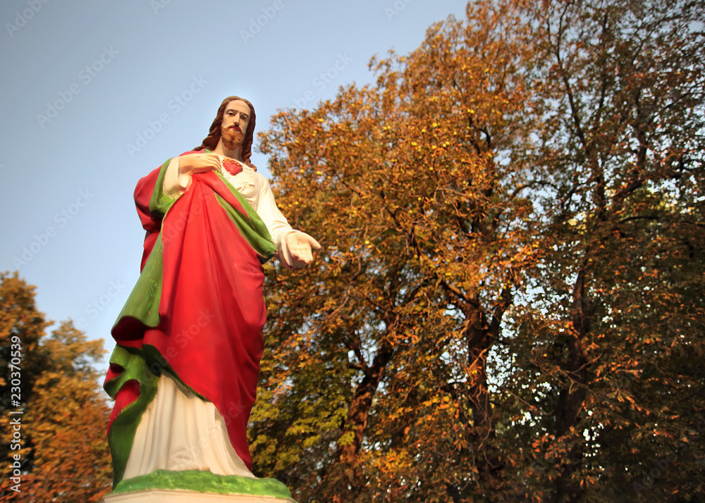 Old statue of Jesus Christ with an outstretched hand on a background of ...