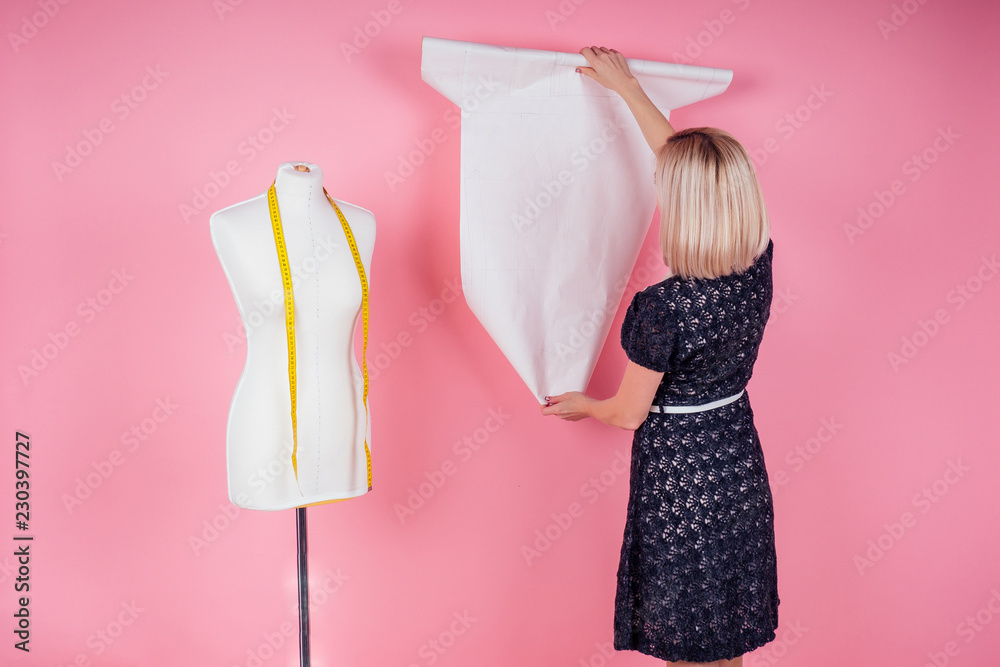 sewing pattern,sewing machine and maniken in studio pink background ...