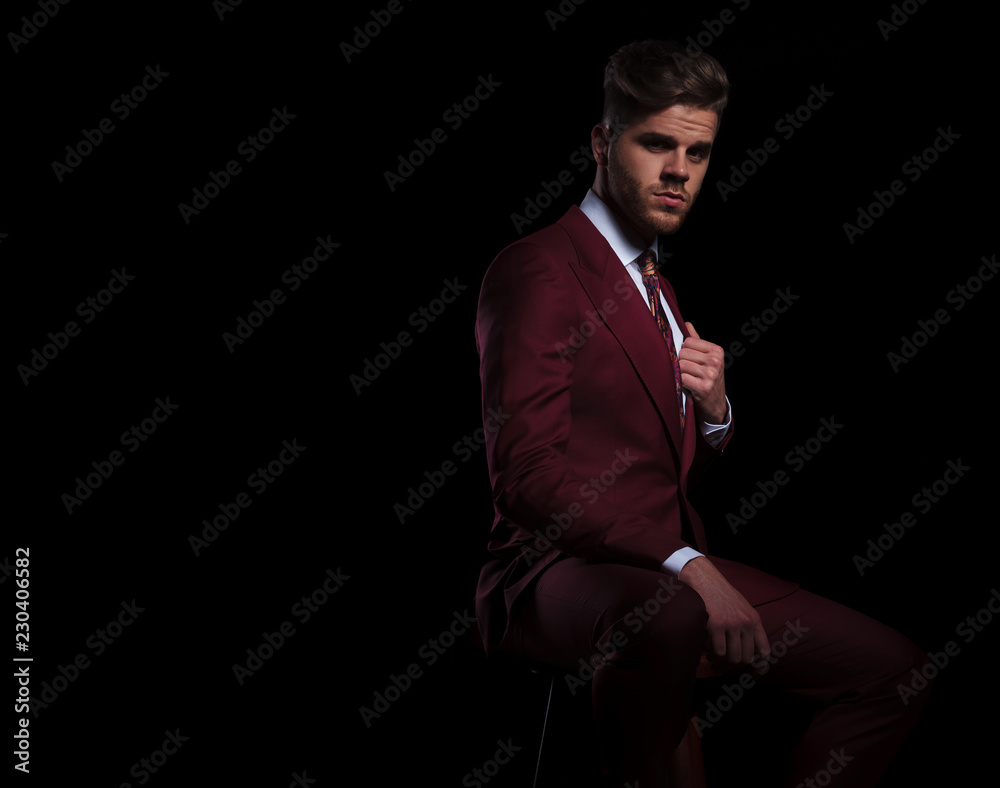 elegant man sitting and holding his collar Stock Photo | Adobe Stock