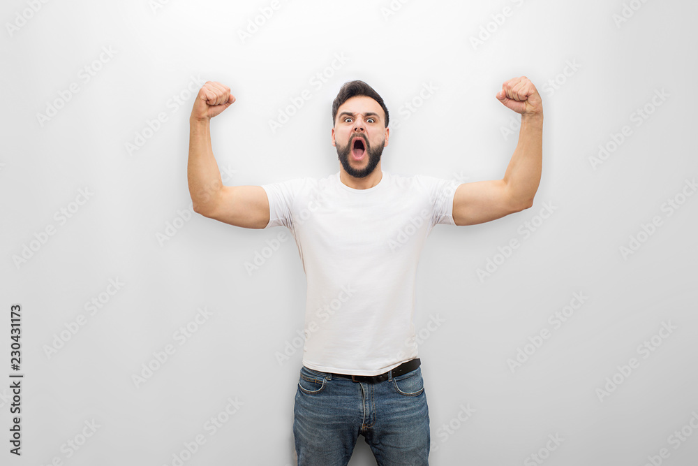 Young man screaming and yelling while posing. He is strong. Guy shows ...