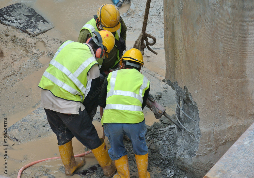 Construction workers cutting foundation pile using hacking method at ...
