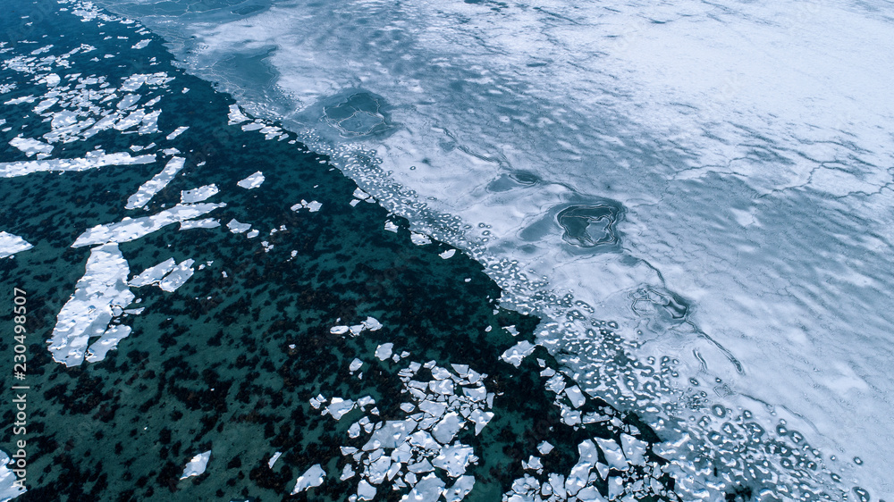 Ice breaking into pieces in a body of water Stock Photo | Adobe Stock