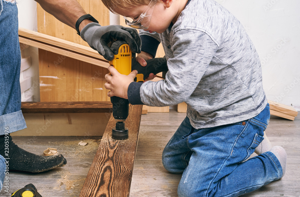 Family time: Dad shows his son hand tools, a yellow screwdriver and a ...