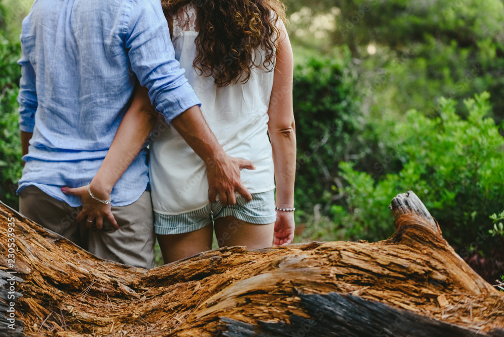 Couple in love seen from behind holding each other and touching their ...