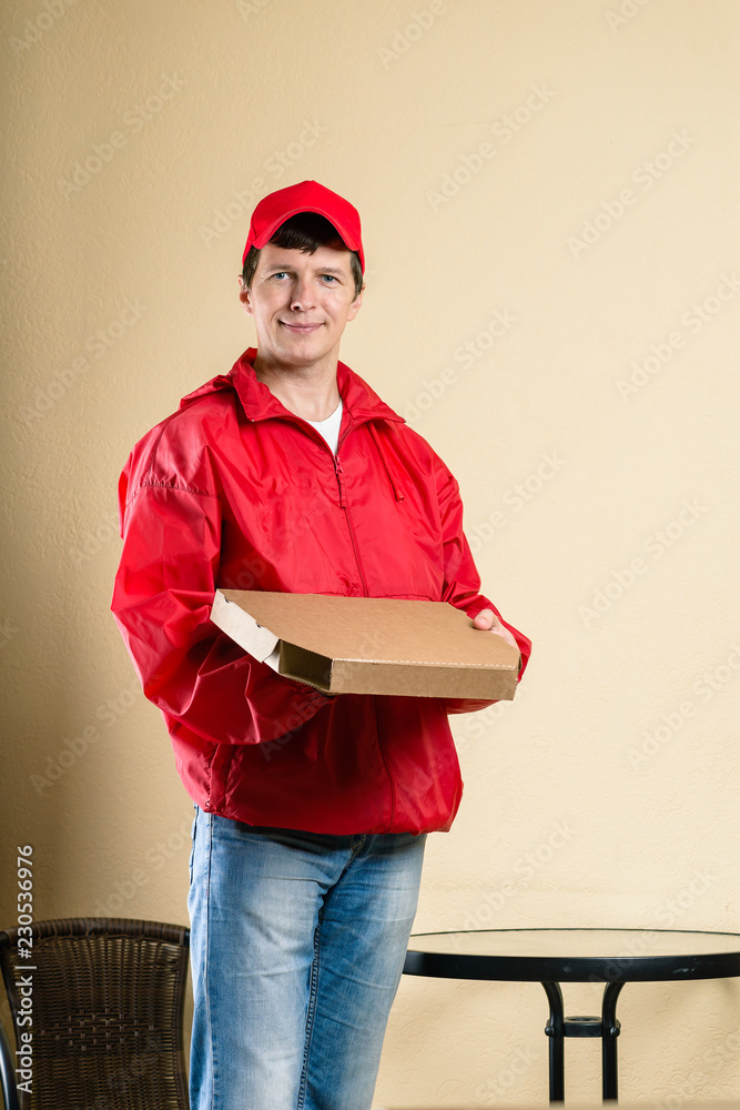 happy man from delivery service in red t-shirt and cap giving food ...