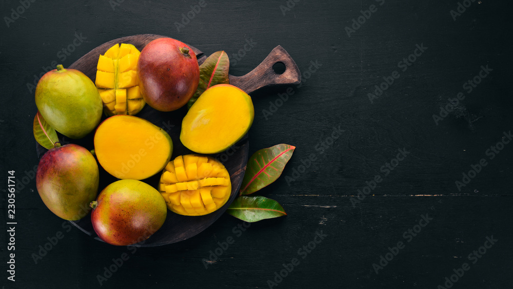 Mango with leaves on a black wooden background. Tropical Fruits. Top ...