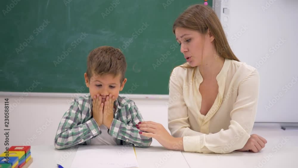 educator female calms crying schoolchild during extracurricular ...