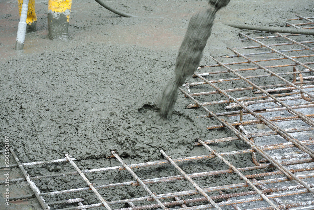 The wet concrete is poured on a steel reinforcement bar to form strong ...