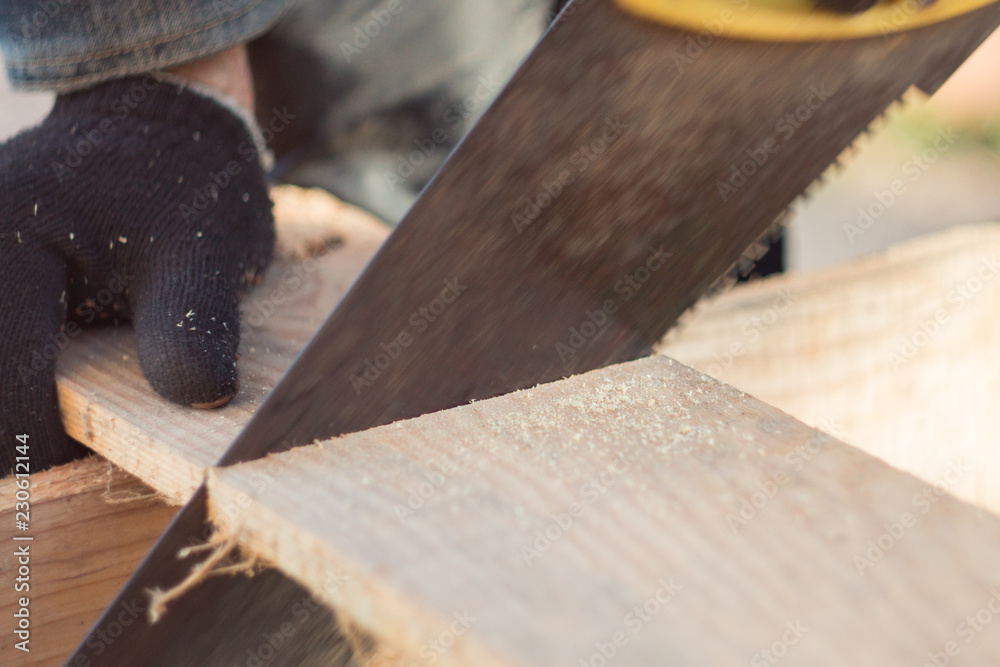 saw boards with a hand saw on a tree, a saw of a tree with a hacksaw ...