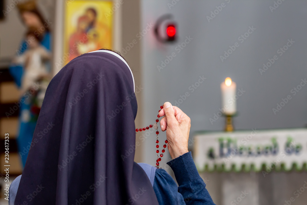 Devotion in the Sanctuary: A Religious Sister Praying with Rosary at ...