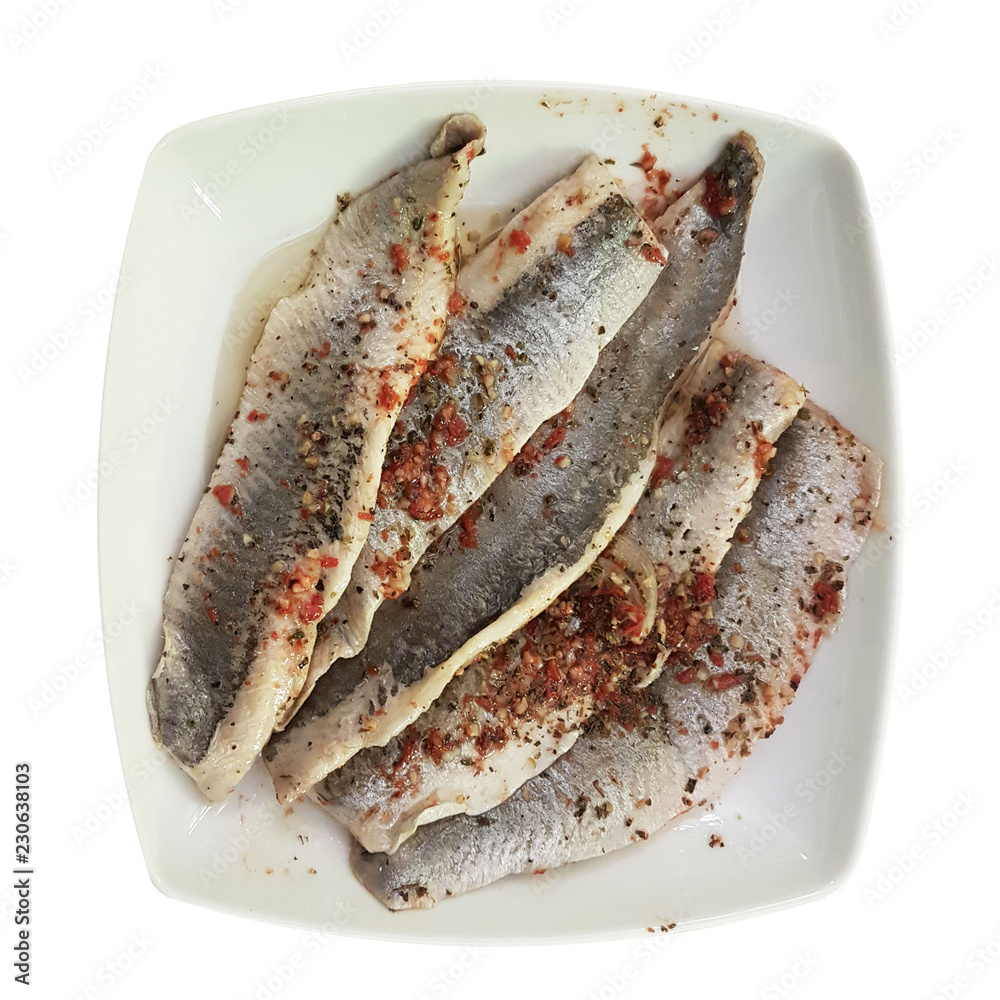A dish of salted fish fillet in oil and seasonings on a plate. Food on ...