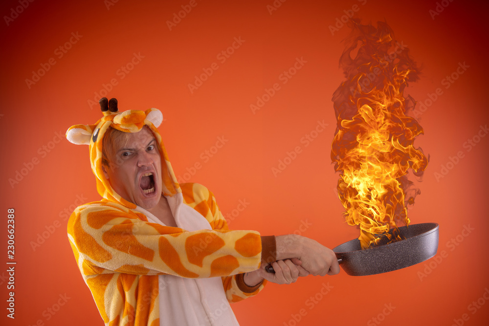 Emotional guy holding a frying pan in his hands, on an orange ...