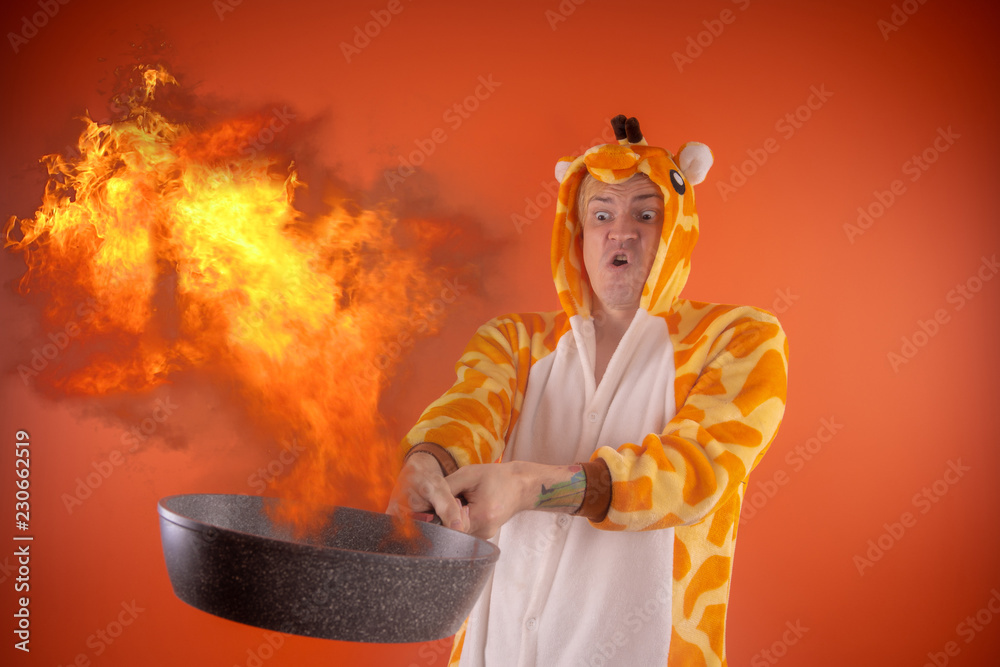 Emotional guy holding a frying pan in his hands, on an orange ...