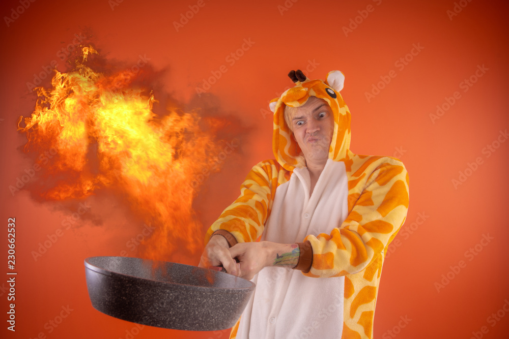 Emotional guy holding a frying pan in his hands, on an orange ...