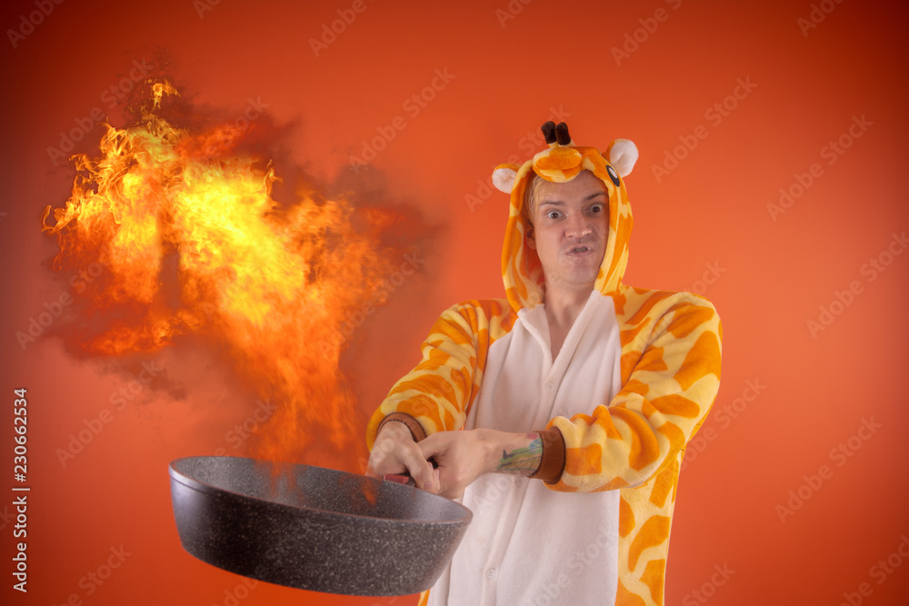 Emotional guy holding a frying pan in his hands, on an orange ...