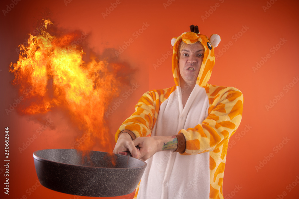 Emotional guy holding a frying pan in his hands, on an orange ...