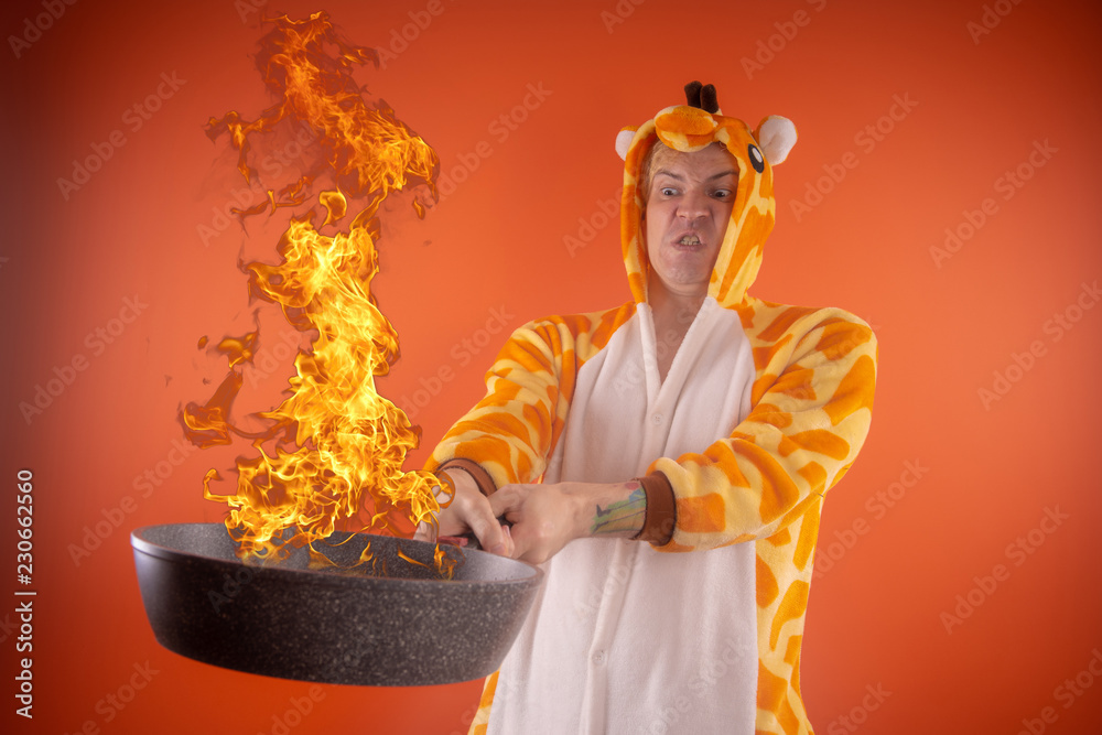 Emotional guy holding a frying pan in his hands, on an orange ...