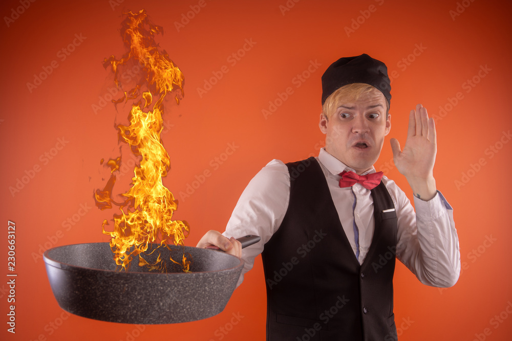 Emotional guy holding a frying pan in his hands, on an orange ...