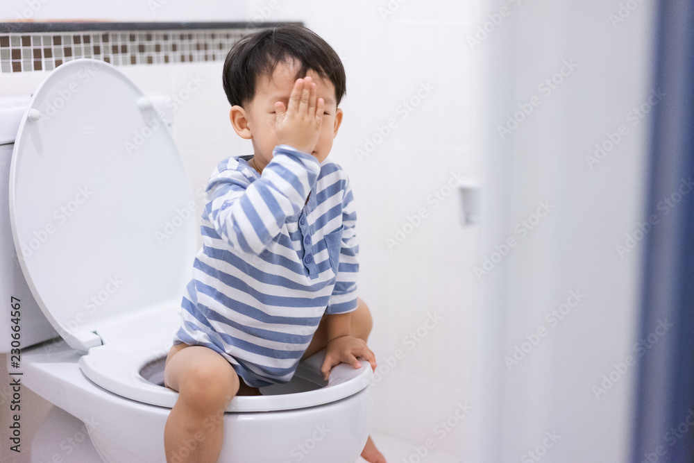Little boy poo and pee in white toilet. Stock Photo | Adobe Stock
