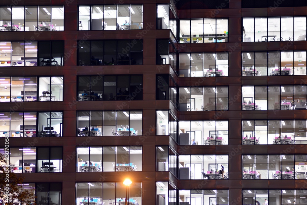 Office building at night. Late night at work. Glass curtain wall office ...