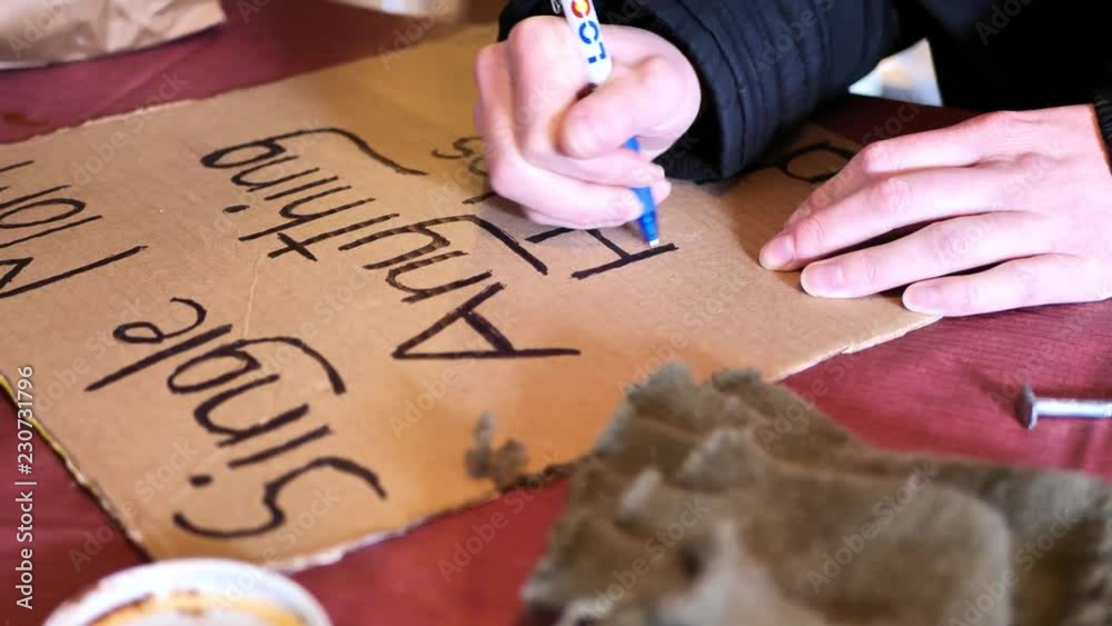 Vidéo Stock Homeless women tracing over and making cardboard sign ...