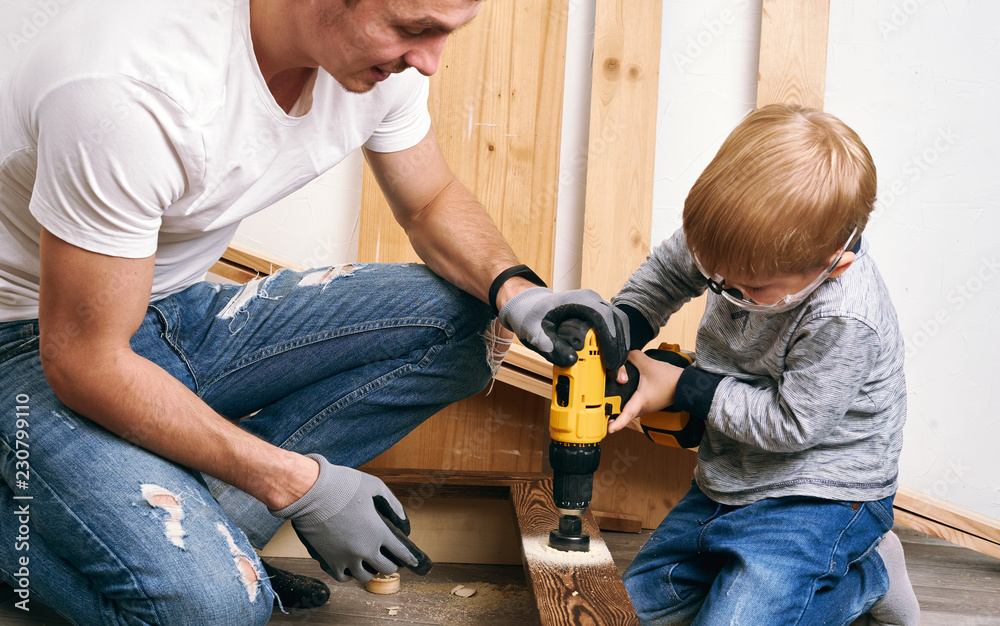 Family time: Dad shows his son hand tools, a yellow screwdriver and a ...
