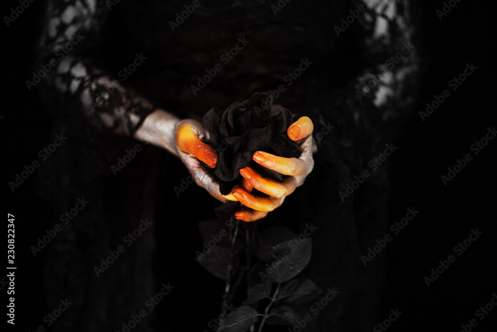 Creepy halloween vampire hands close up in red orange and silver ...
