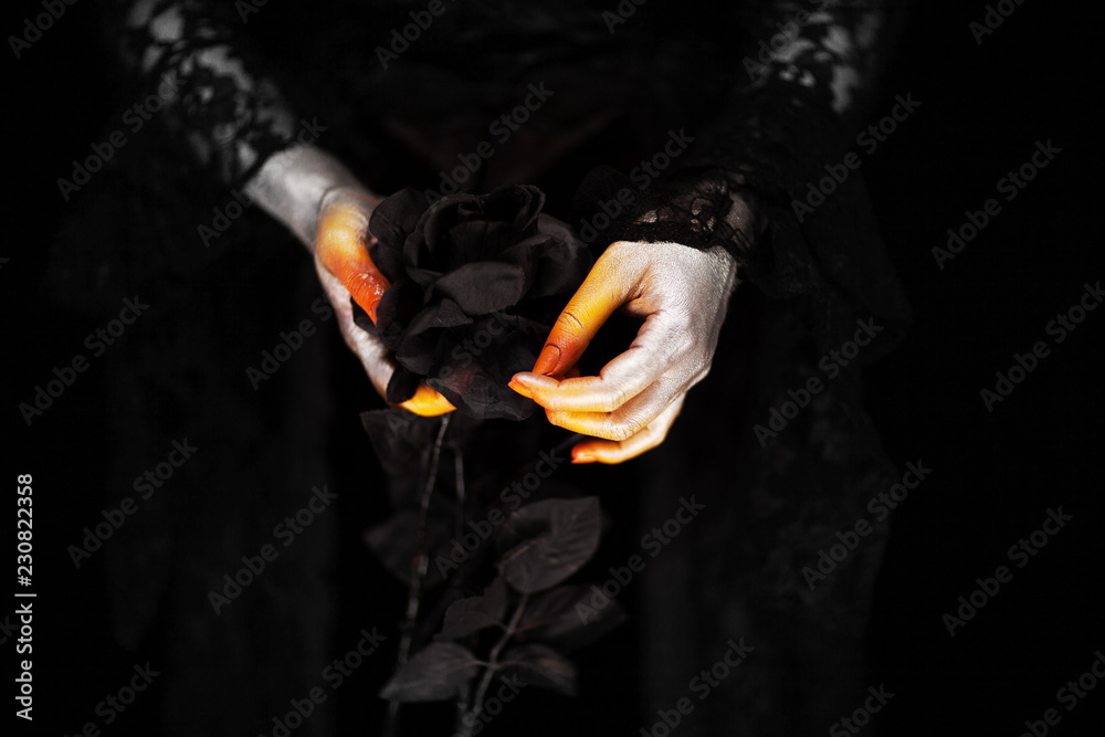 Creepy halloween vampire hands close up in red orange and silver ...