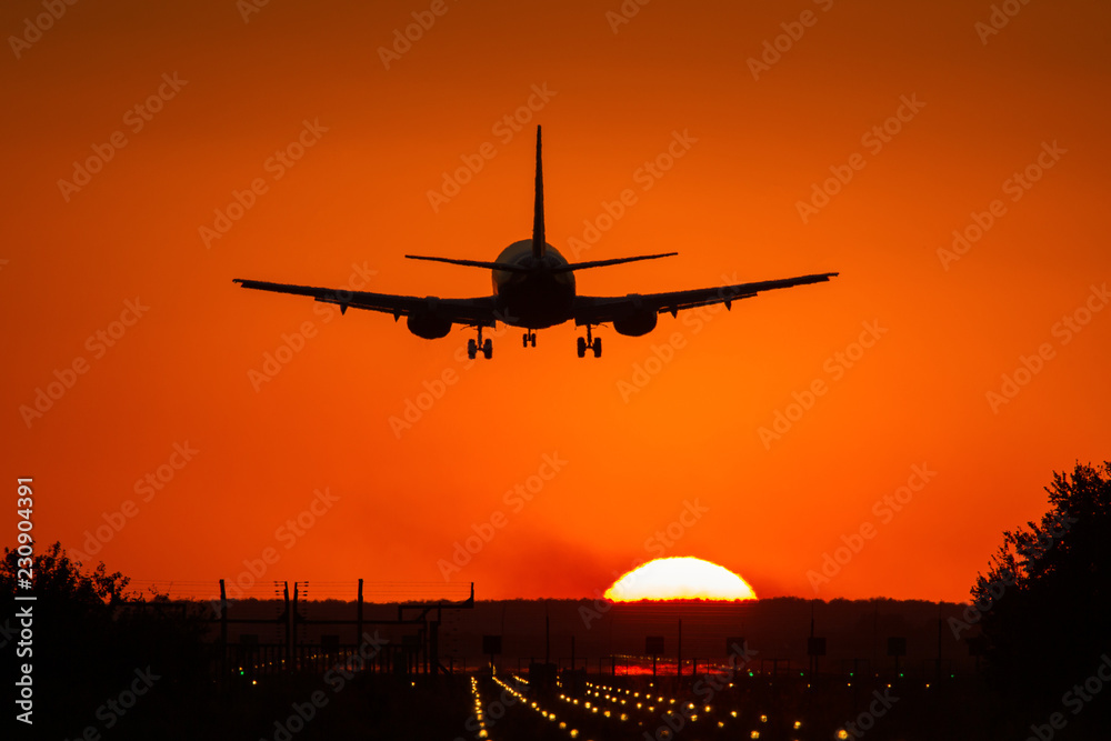 Plane Landing At Sunset