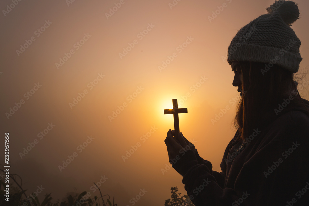 Silhouette of woman hands praying with cross in nature sunrise ...
