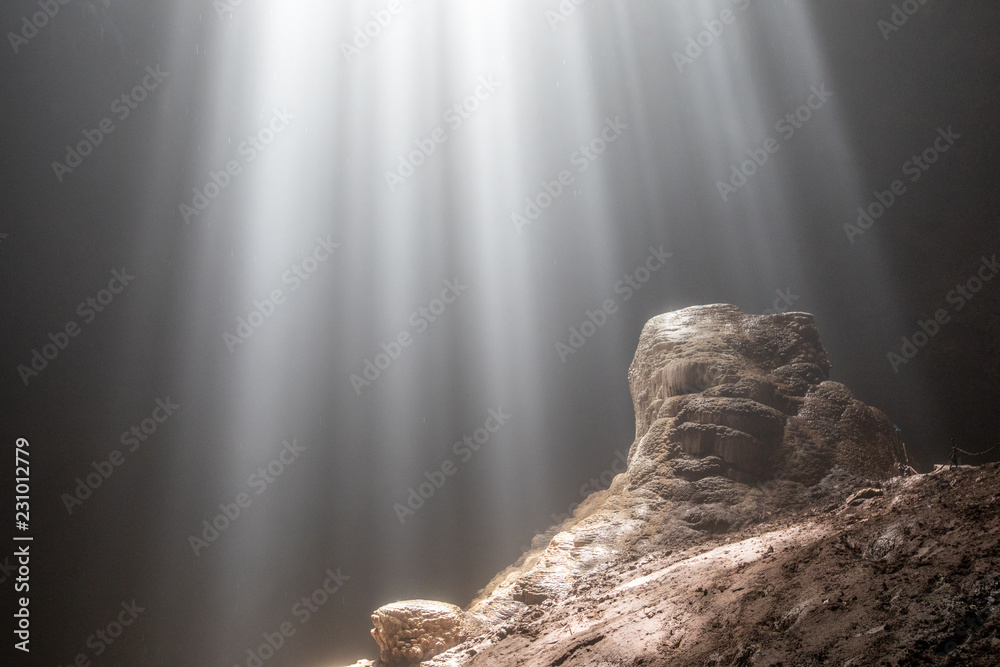 Foto de Light rays shining on a rock inside cave Goa Jomblang in East ...