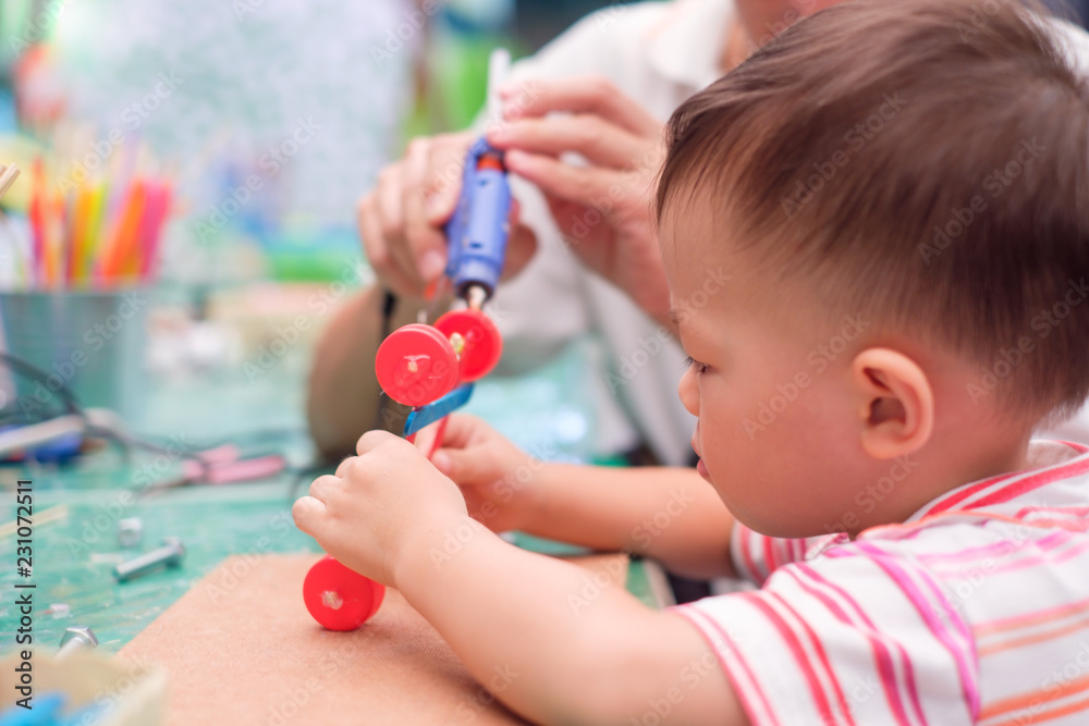 Asian Father teaching kid make a car toy with recycled materials ...