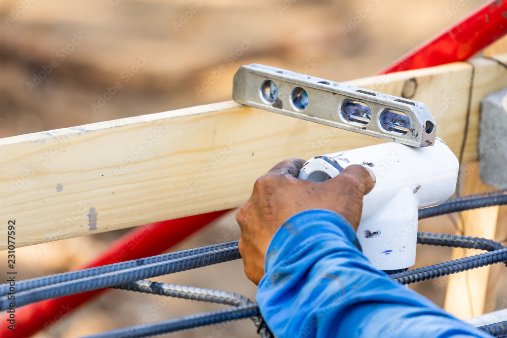Plumber Using Level While Installing PVC Pipe At Construction Site ...