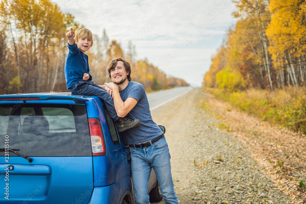 Dad and son are resting on the side of the road on a road trip. Road ...