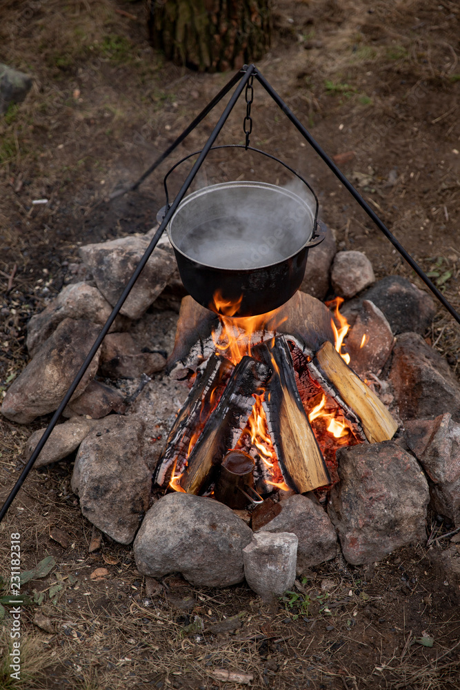 Cooking on a fire. Fish soup on a fire. Food in a cauldron on a fire ...