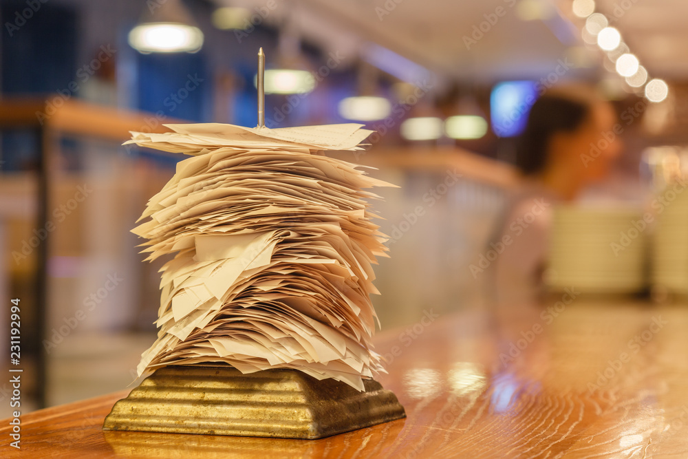 Checks from completed orders in the bar or restaurant kitchen impaled ...