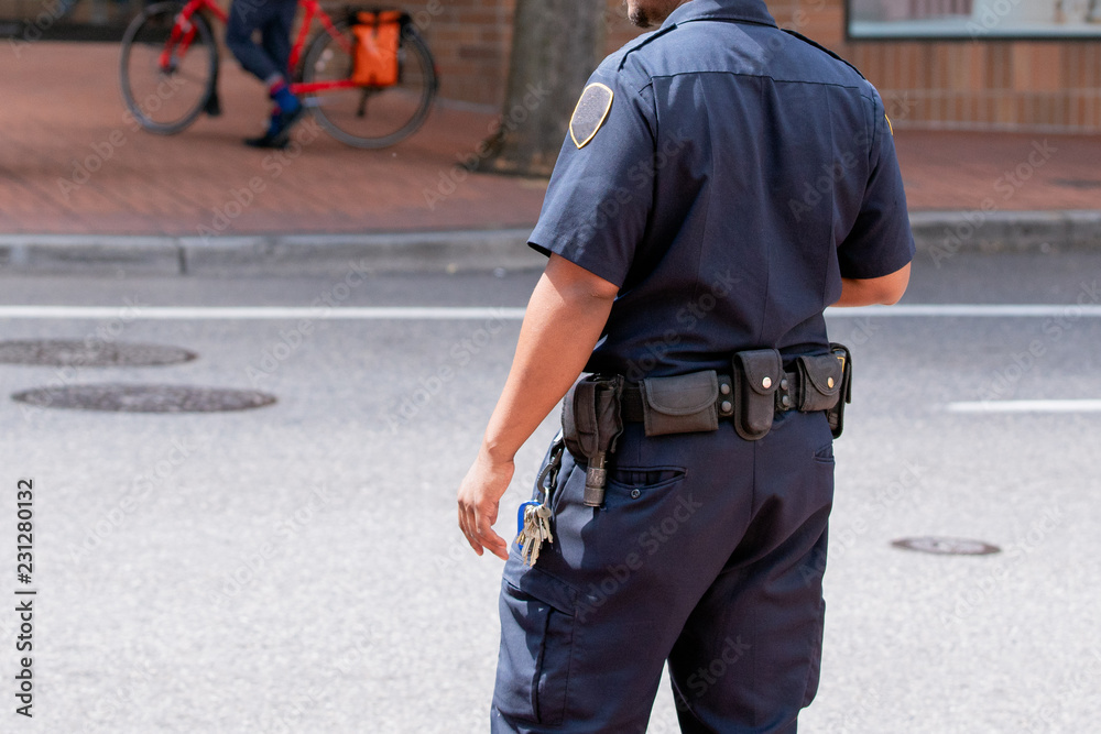 Security guard standing on a street wearing a utility belt with many ...