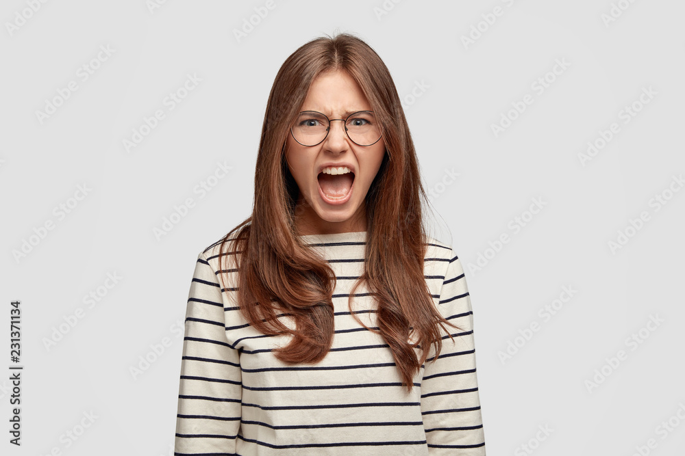 Portrait of emotional brunette woman screams very loudly, has ...