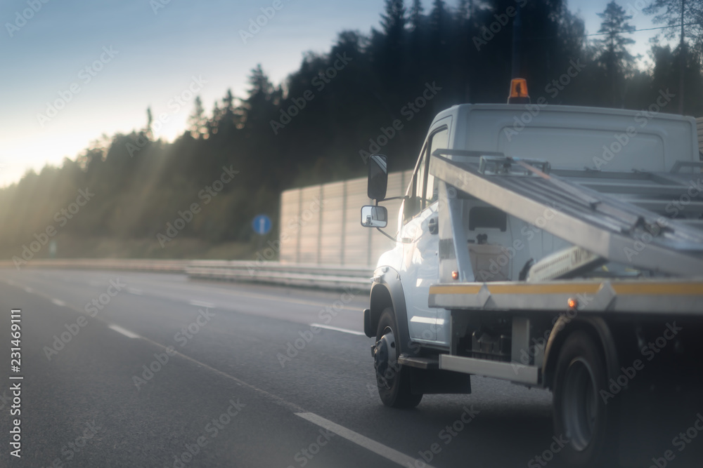 A white car hauler truck with an empty two-tiered trailer for ...